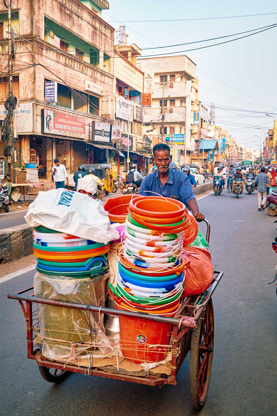 A delivery man taking plastic buckets in his tricycle at Rayapettah ...